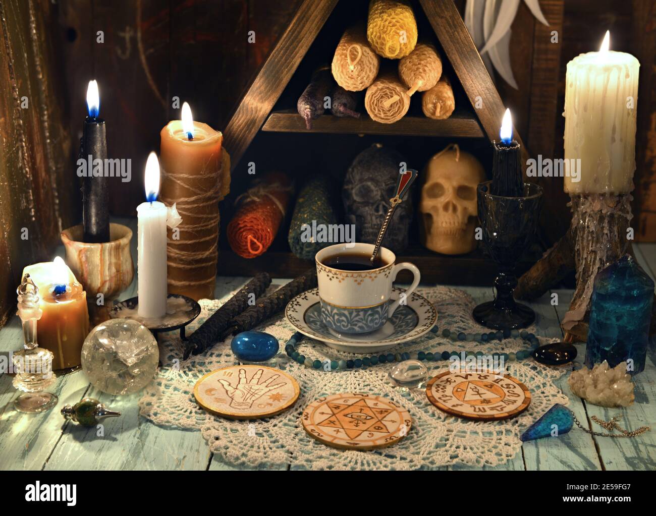 Prediction ritual with cup of tea, burning candles and crystals on ...