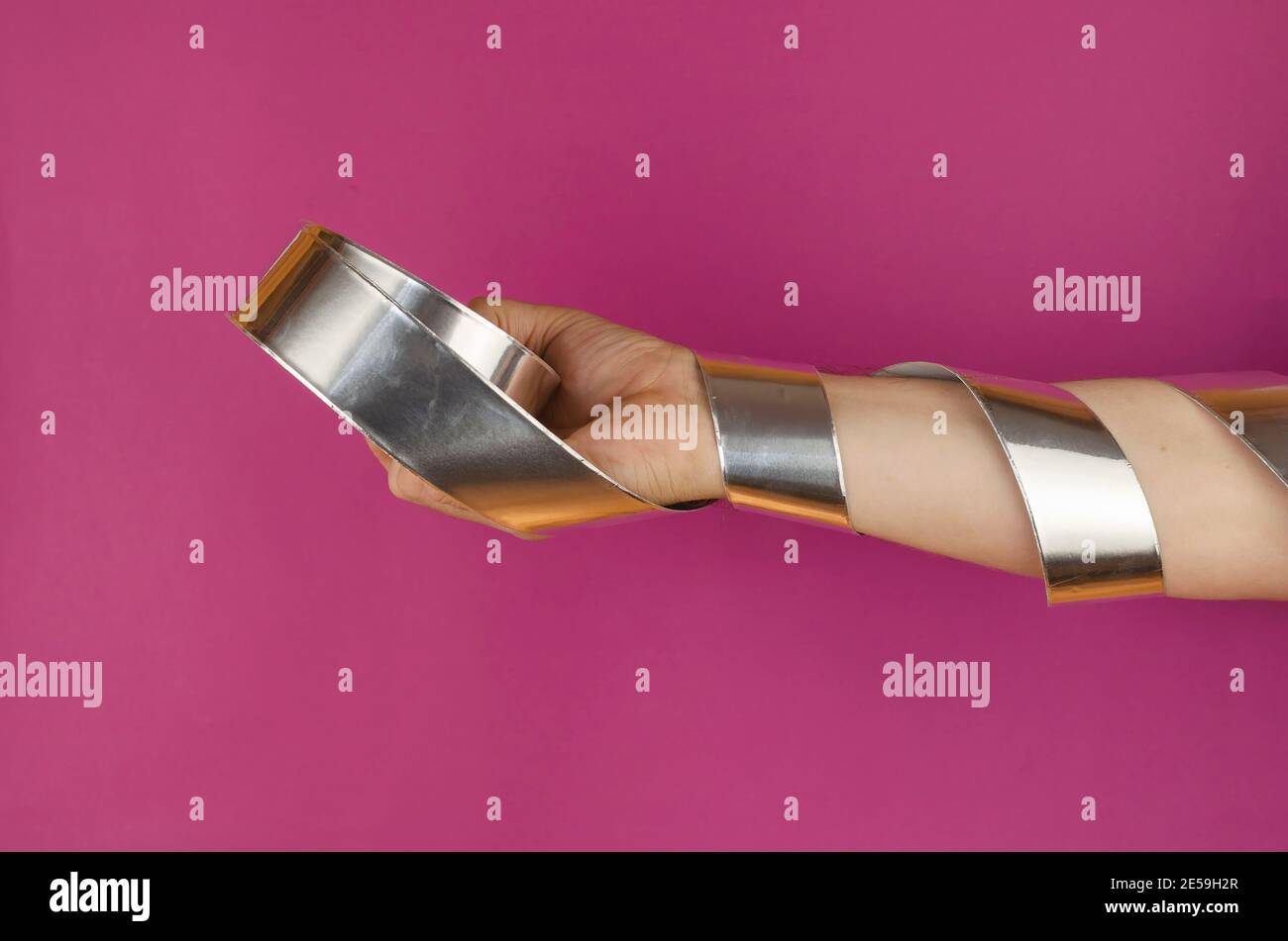 Hand wrapped with aluminum duct tape for padding. Man's hand with roll ...