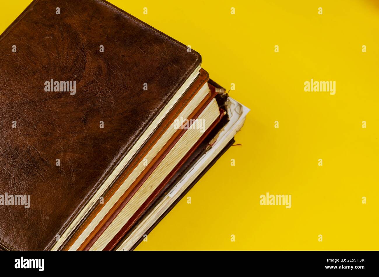 Stack of old diaries lying on yellow background. Diaries have worn ...