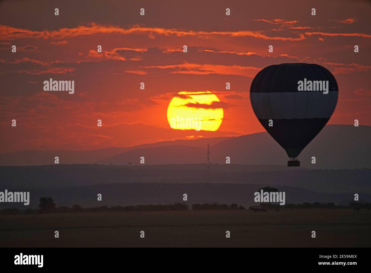 Sunset, hot air balloon silhouette, meadows and mountains. Large ...