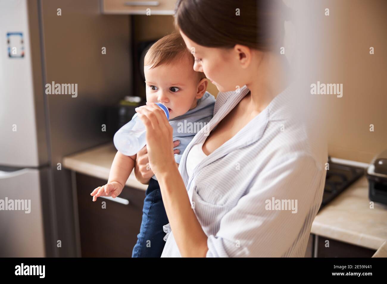 Attentive female person looking at her kid Stock Photo - Alamy