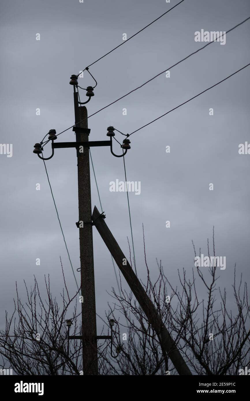 Electric pillar with wires in dark overcast sky Stock Photo - Alamy