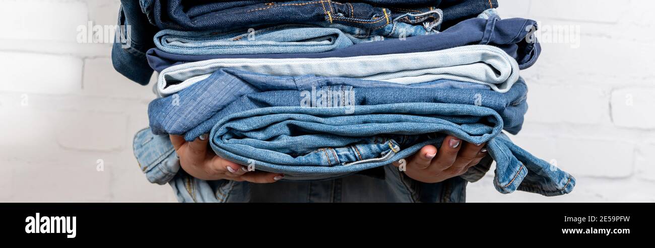 partial view of woman with stacked denim clothes, banner Stock Photo ...