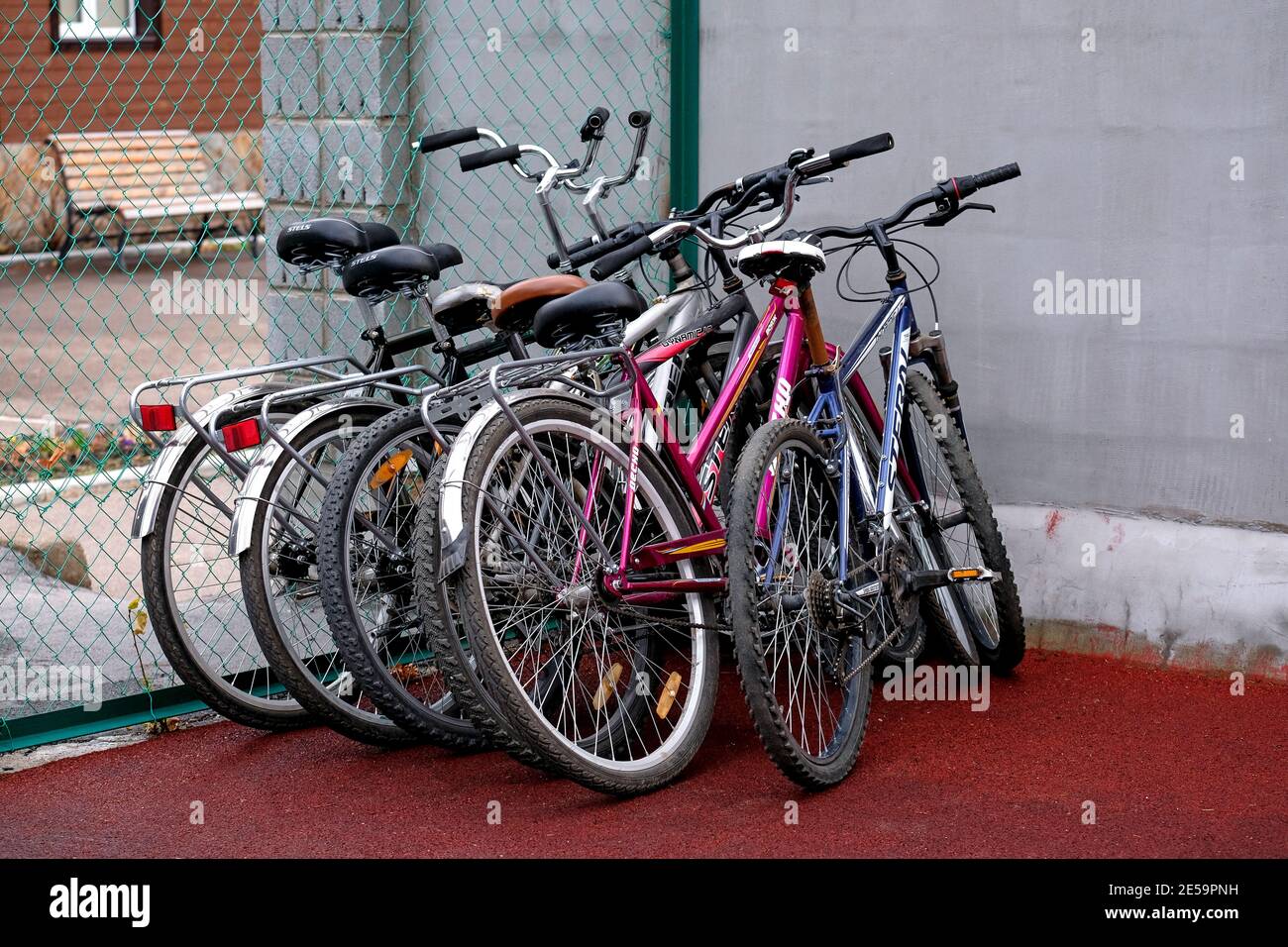 Bicycle storage. Several old bikes stand together by the fence Stock ...