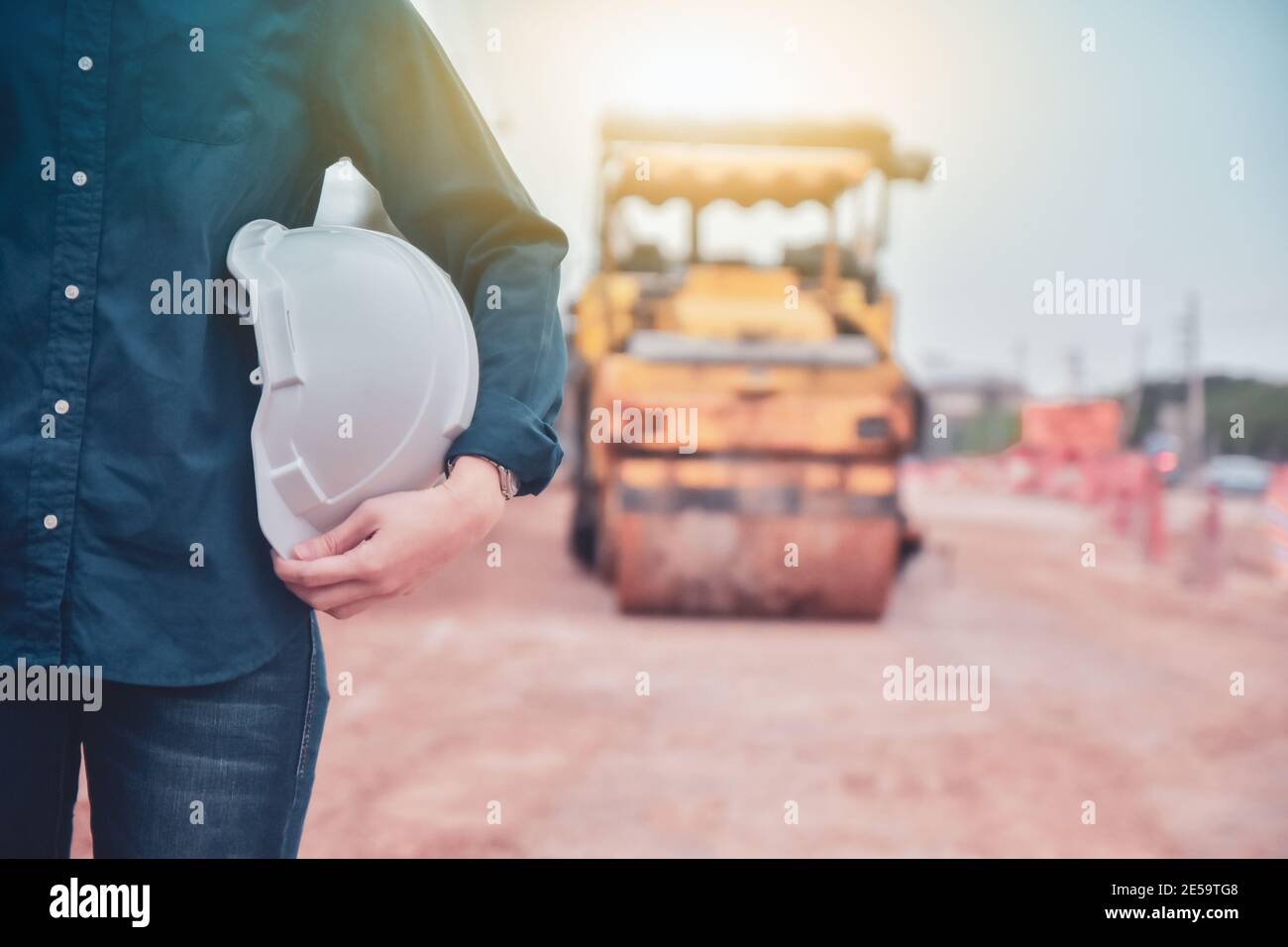 Close up engineer holding hard hat standing on road construction ...