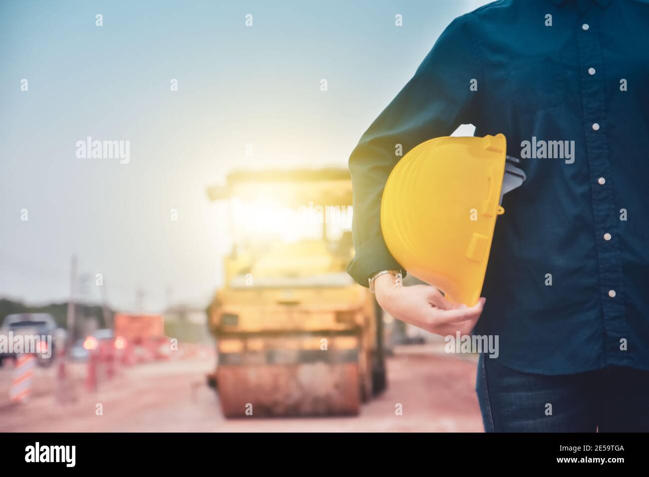 Close up engineer holding hard hat standing on road construction ...