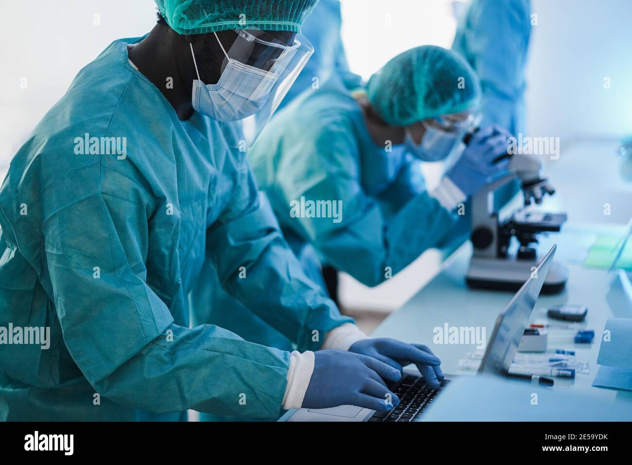 Medical workers in hazmat suit working with laptop computer and ...