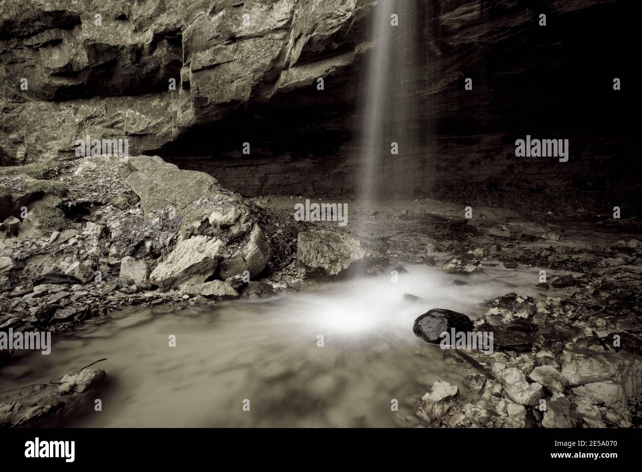 Monochromatic image of the Small waterfall in front limestone cave in ...