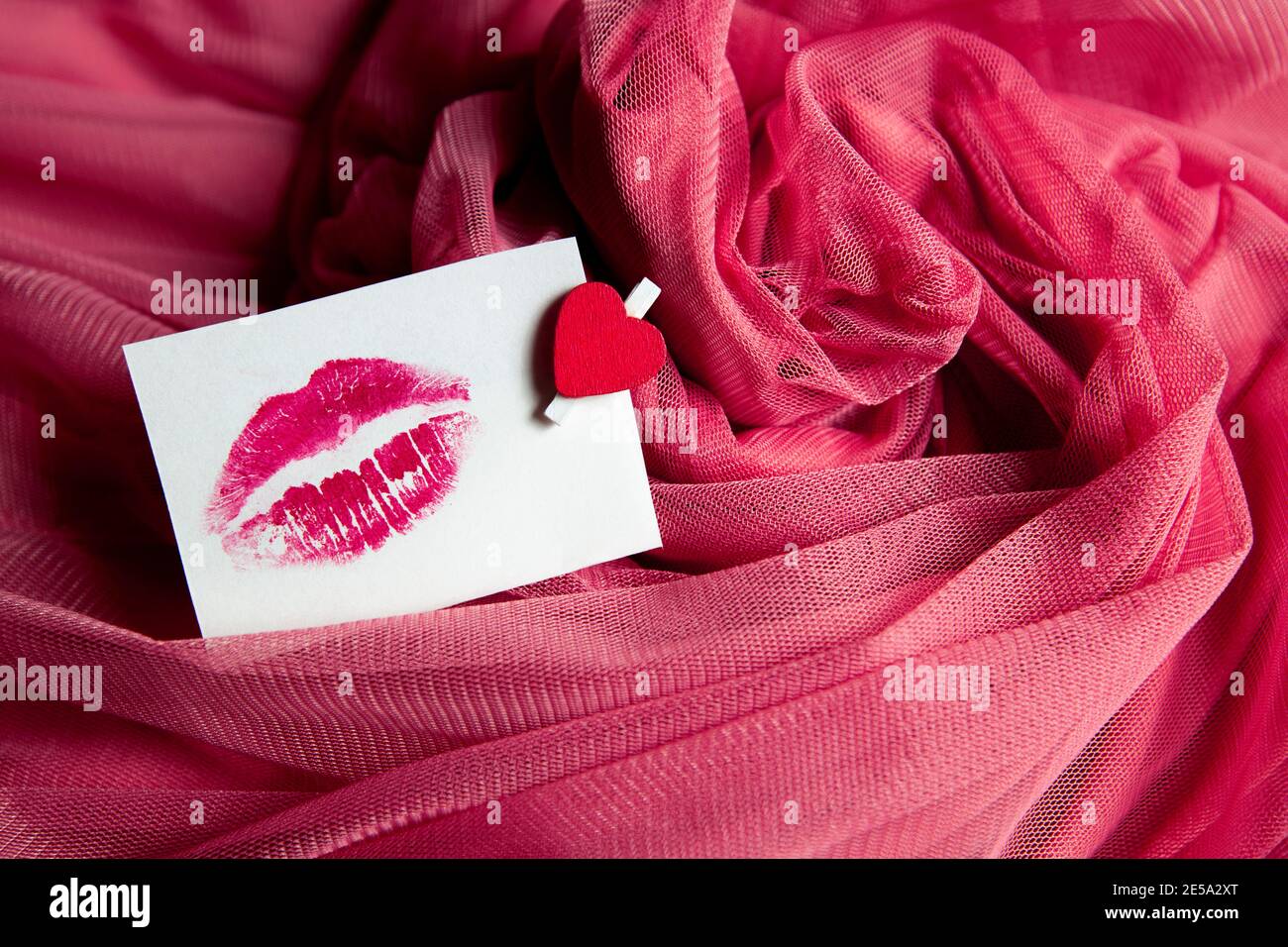 paper sticker with kiss on pink crumpled cloth background Stock Photo ...