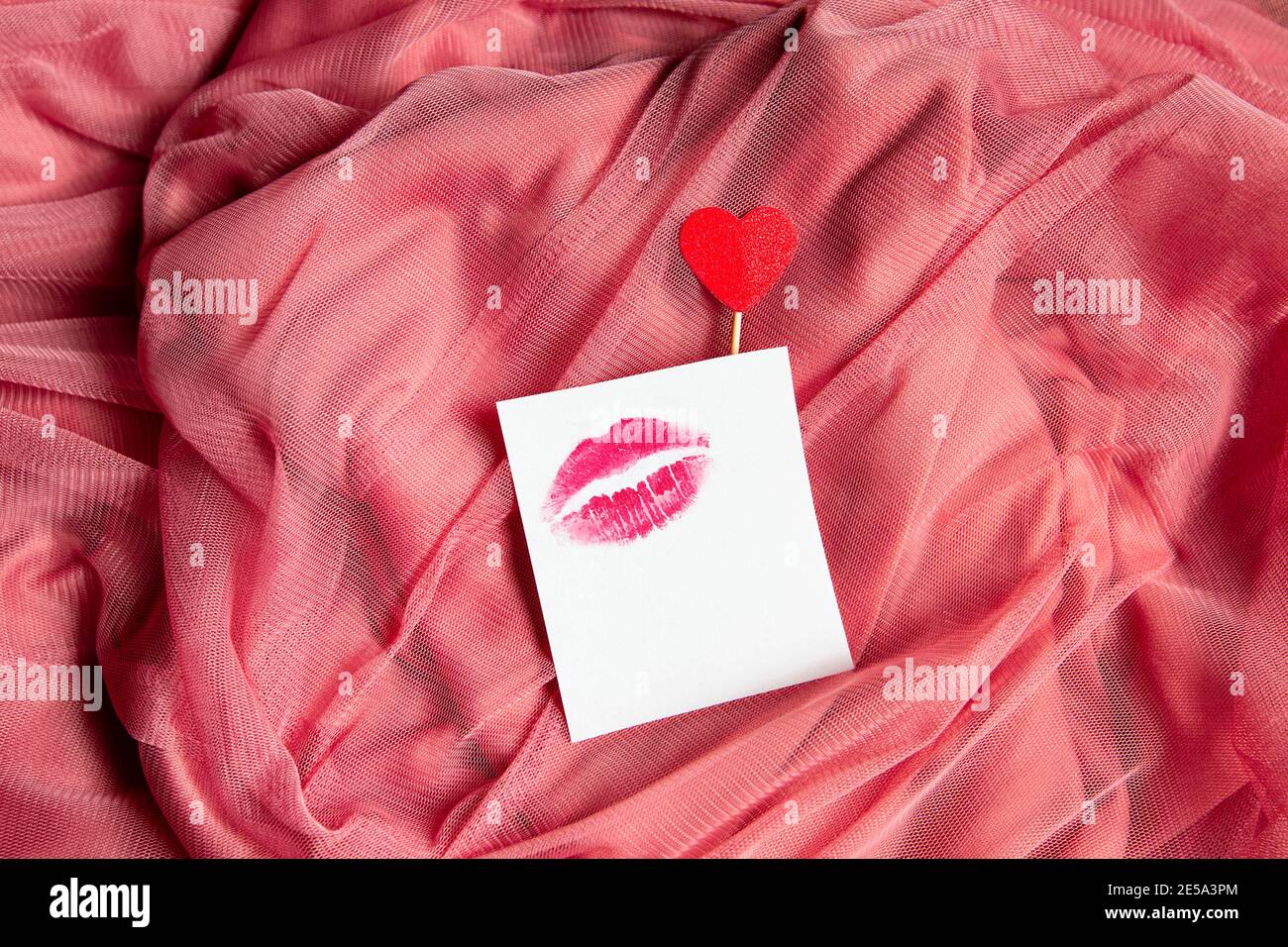 paper sticker with kiss on pink crumpled cloth background Stock Photo ...