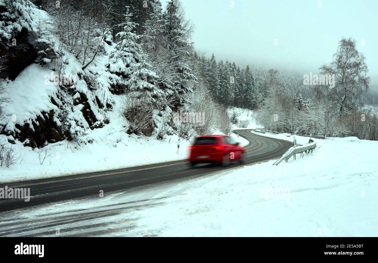 Winding cleared gray asphalt road in Harz mountains with fresh snow on ...