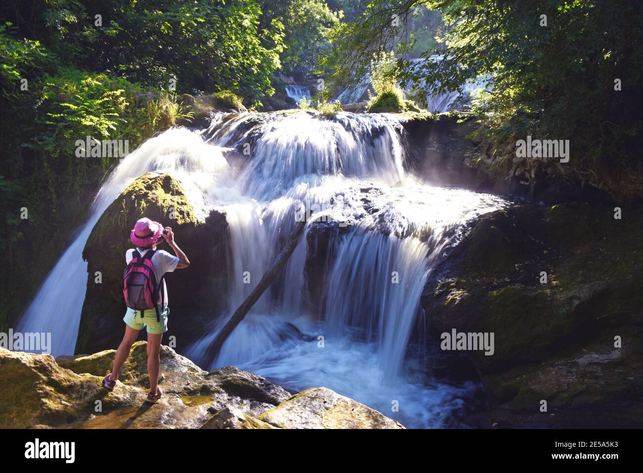woman taking photos of a waterfall ot the river Caramy, France ...