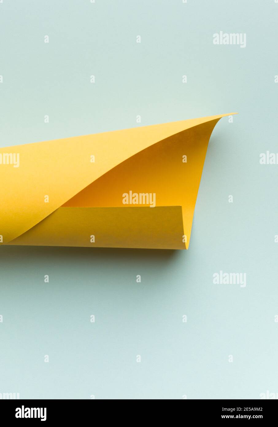The bright yellow sheet paper on a on lite blue background Stock Photo ...