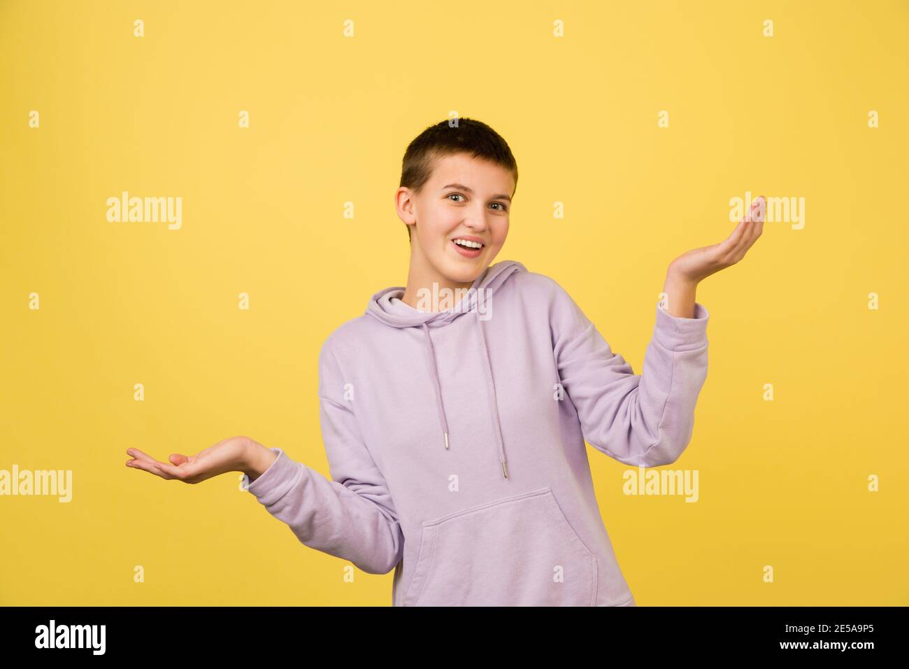 Showing, uncertain. Caucasian girl's portrait isolated on yellow ...