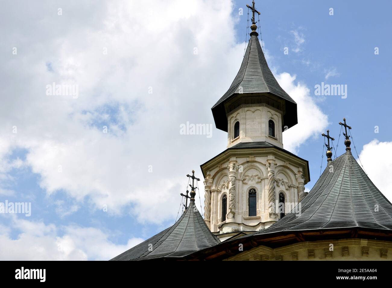 Bottom view of church turrets with crosses on cloudy sky background ...