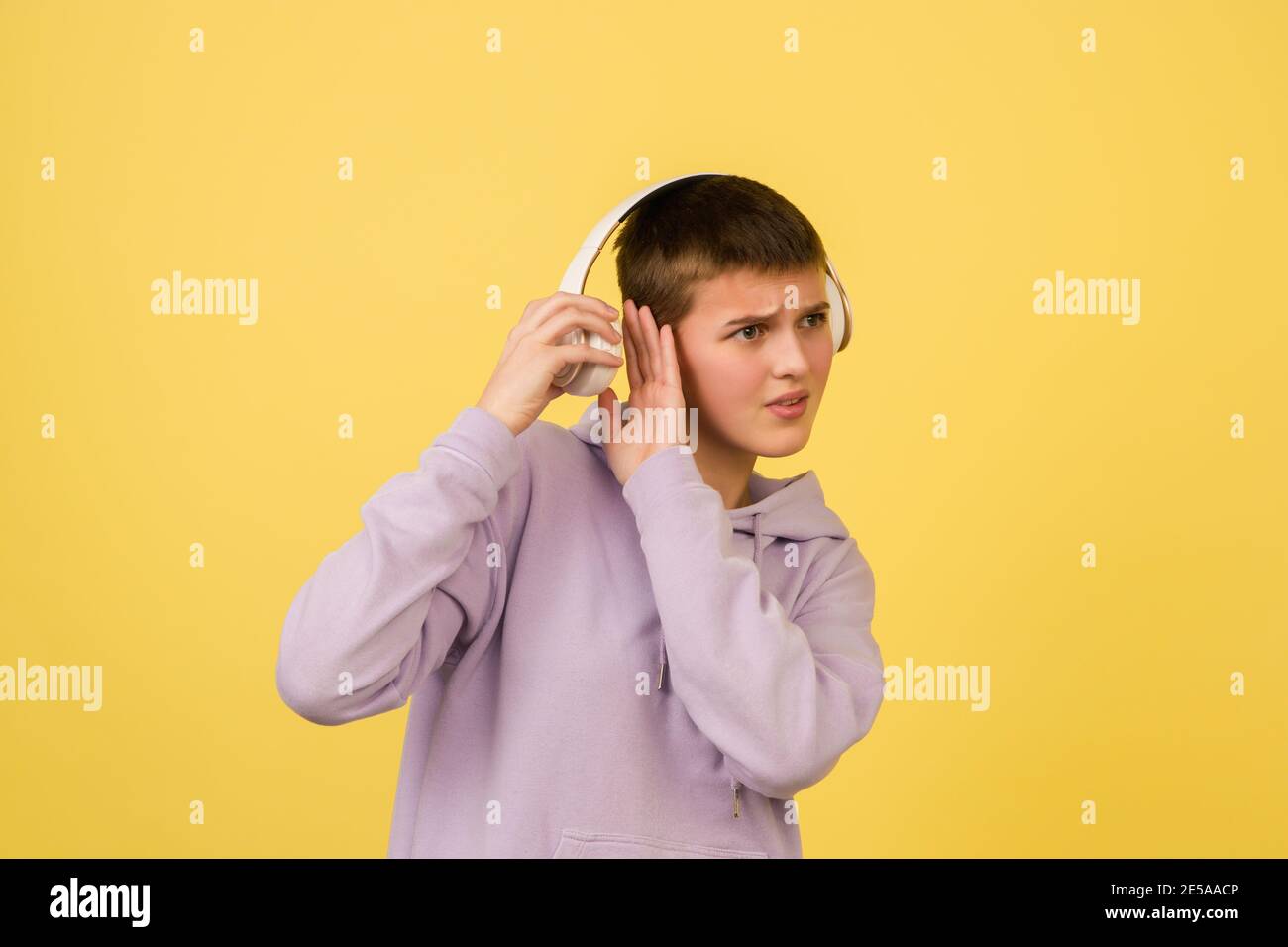 Disappointed of music. Caucasian girl's portrait on yellow background ...
