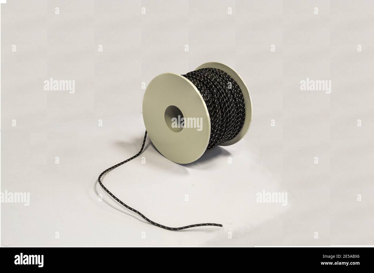 Closeup shot of a black thread with white dots on a white surface Stock ...