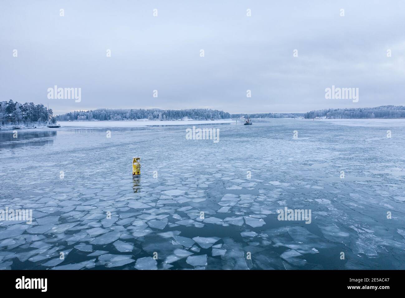 Icy sea conditions with a tug boat on a distance Stock Photo - Alamy