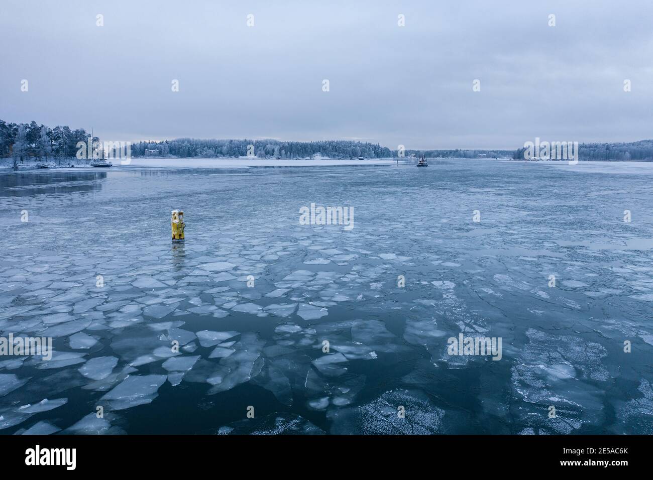 Icy sea conditions with a tug boat on a distance Stock Photo - Alamy
