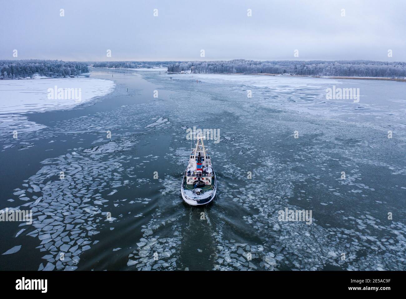 Tug boat pushing through the ice on a sea in winter Stock Photo - Alamy