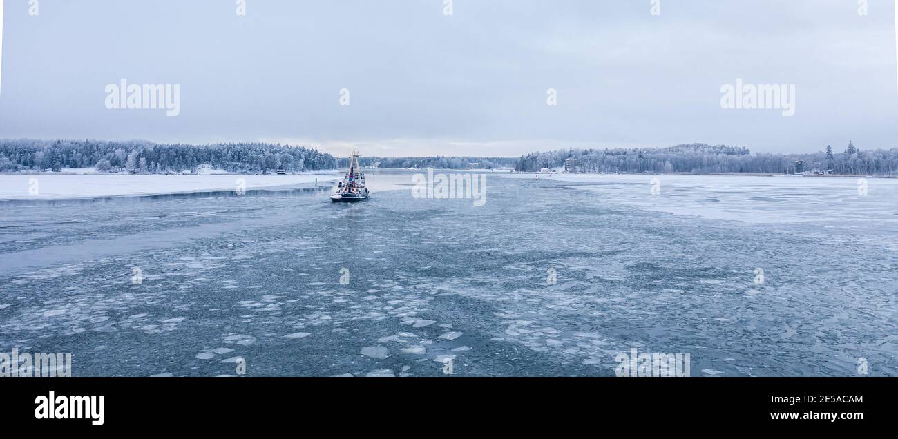 Icy sea conditions with a tug boat on a distance Stock Photo - Alamy