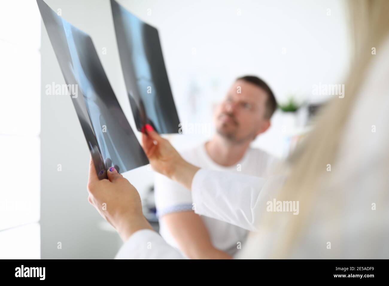 Doctor showing x-rays to patient in clinic closeup Stock Photo - Alamy