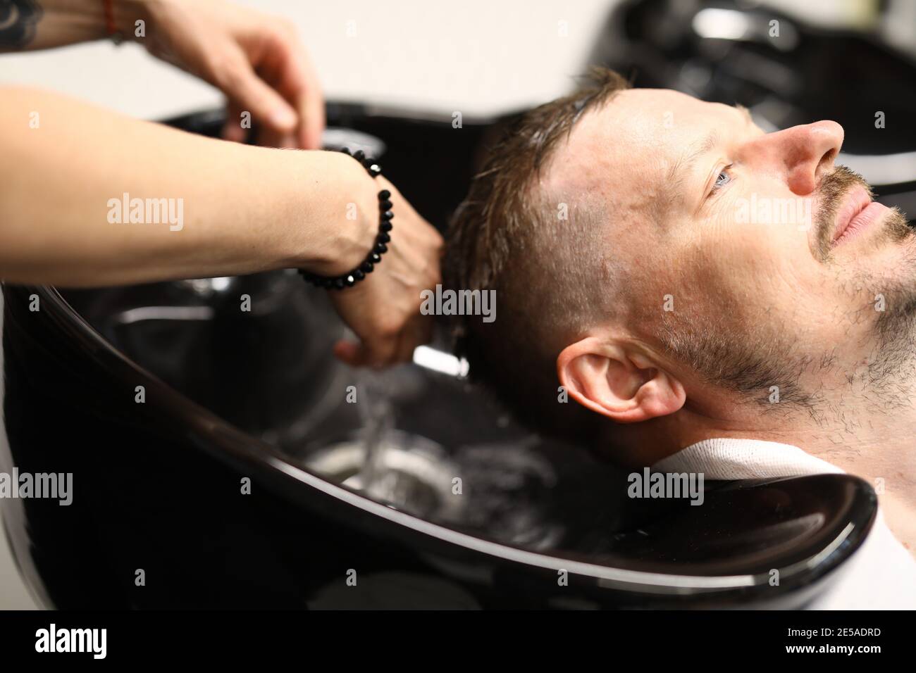 Hairdresser washing mans head in beauty salon Stock Photo - Alamy