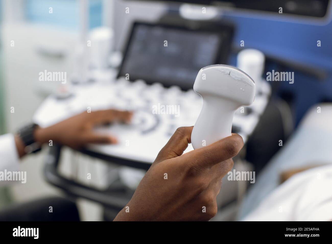 Close up photo of ultrasound scanner in the hands of male African ...