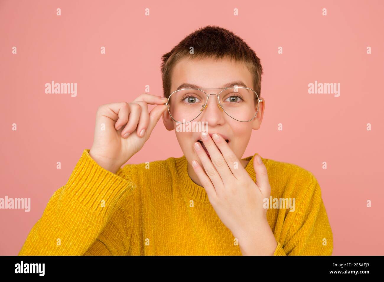 Shocked laughting. Caucasian girl's portrait on coral pink studio ...