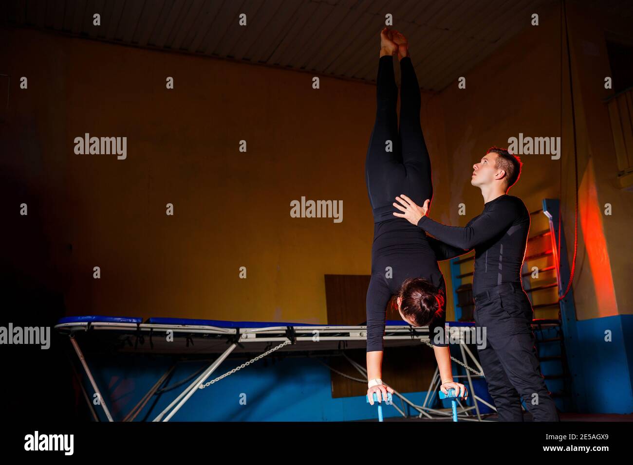 Young woman and man gymnasts do acrobatic exercises in the gym. Sports ...