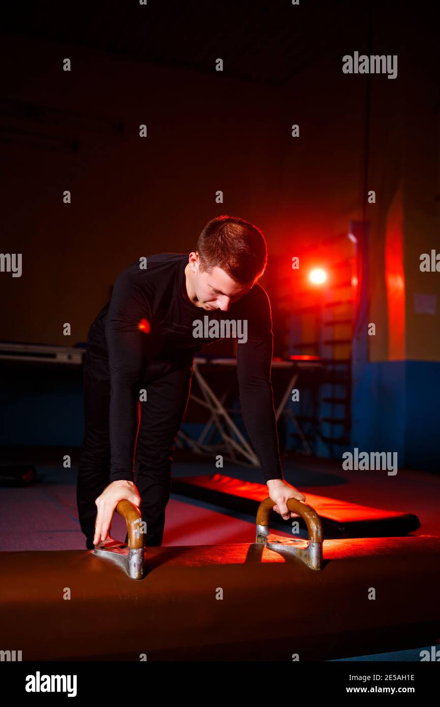 Young strong man doing handstand exercises. Male gymnast doing sports ...