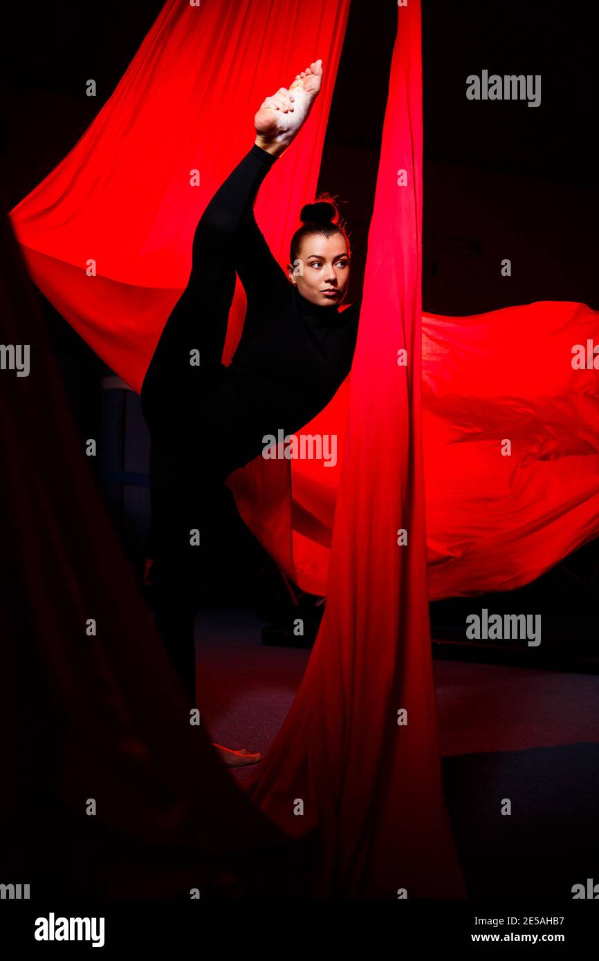 A beautiful sportive girl acrobat performs gymnastic and circus ...