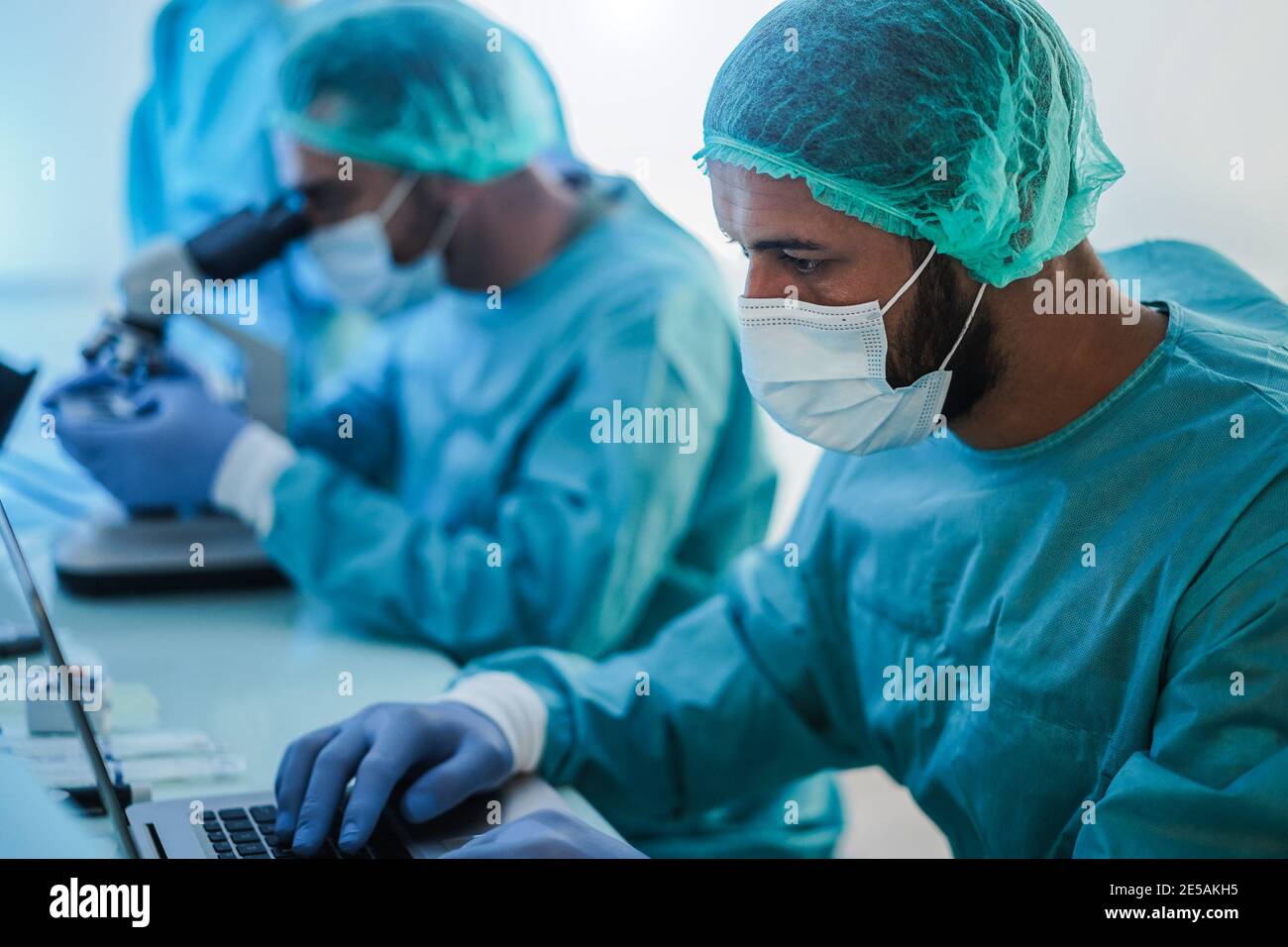 Medical workers in hazmat suit working with laptop computer and ...