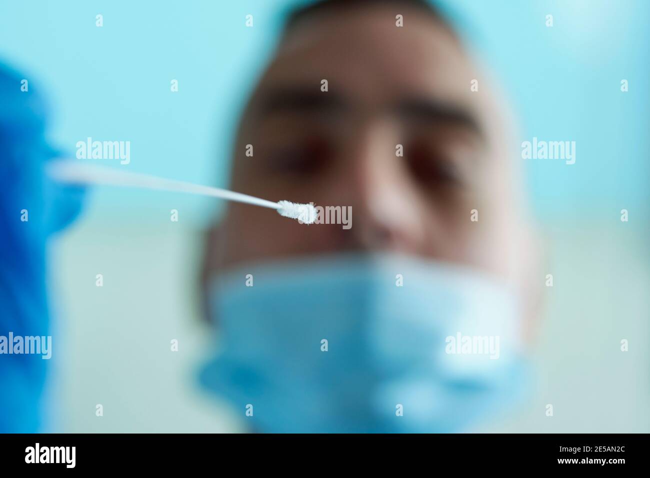closeup of a healthcare worker, wearing blue surgical gloves, about to ...