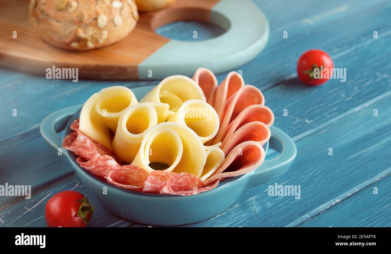 Italian salami, sausage and cheese in ceramic bowl. Cherry tomatoes ...
