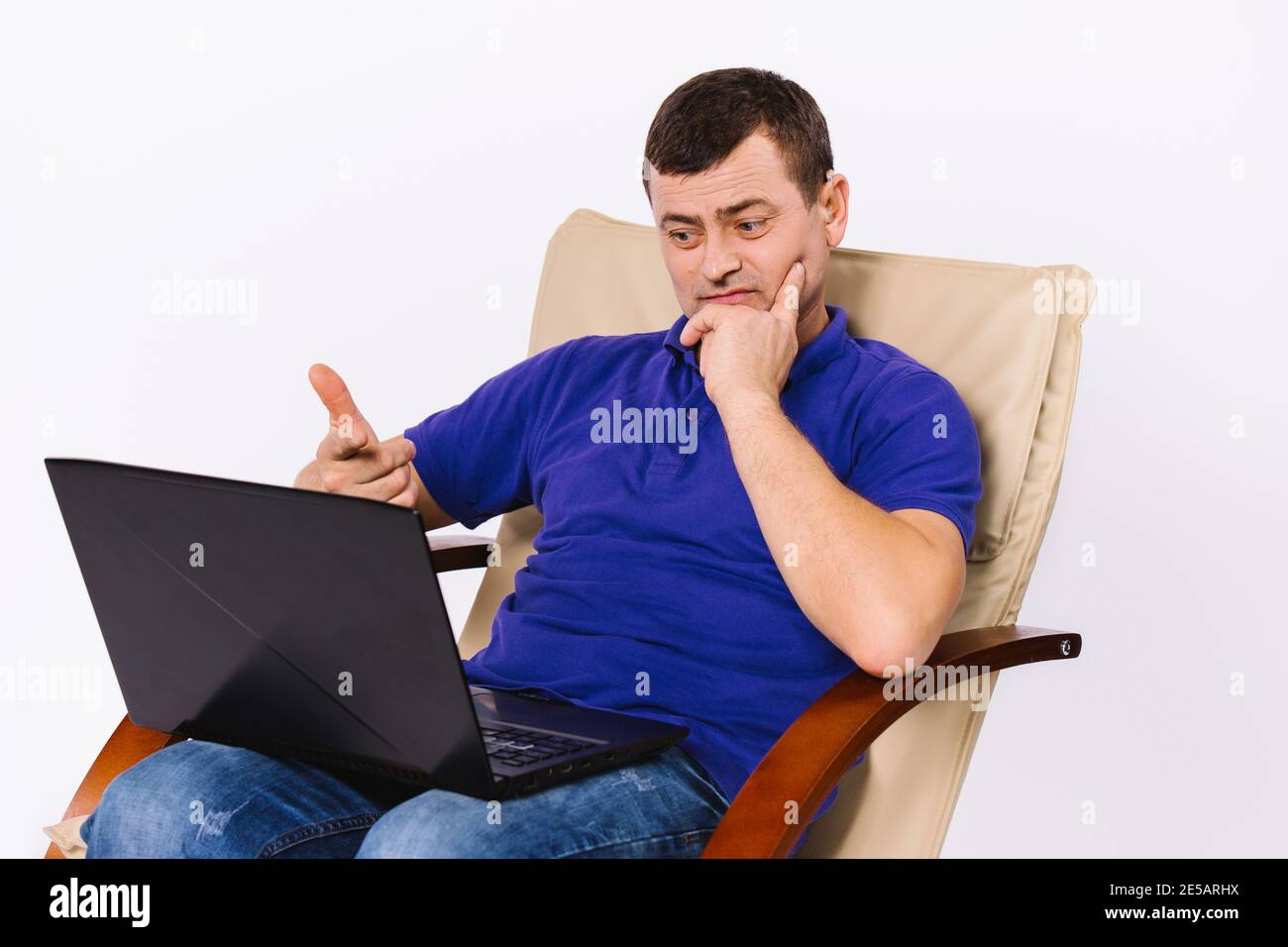 An older deaf man communicates online via a laptop on video using sign ...