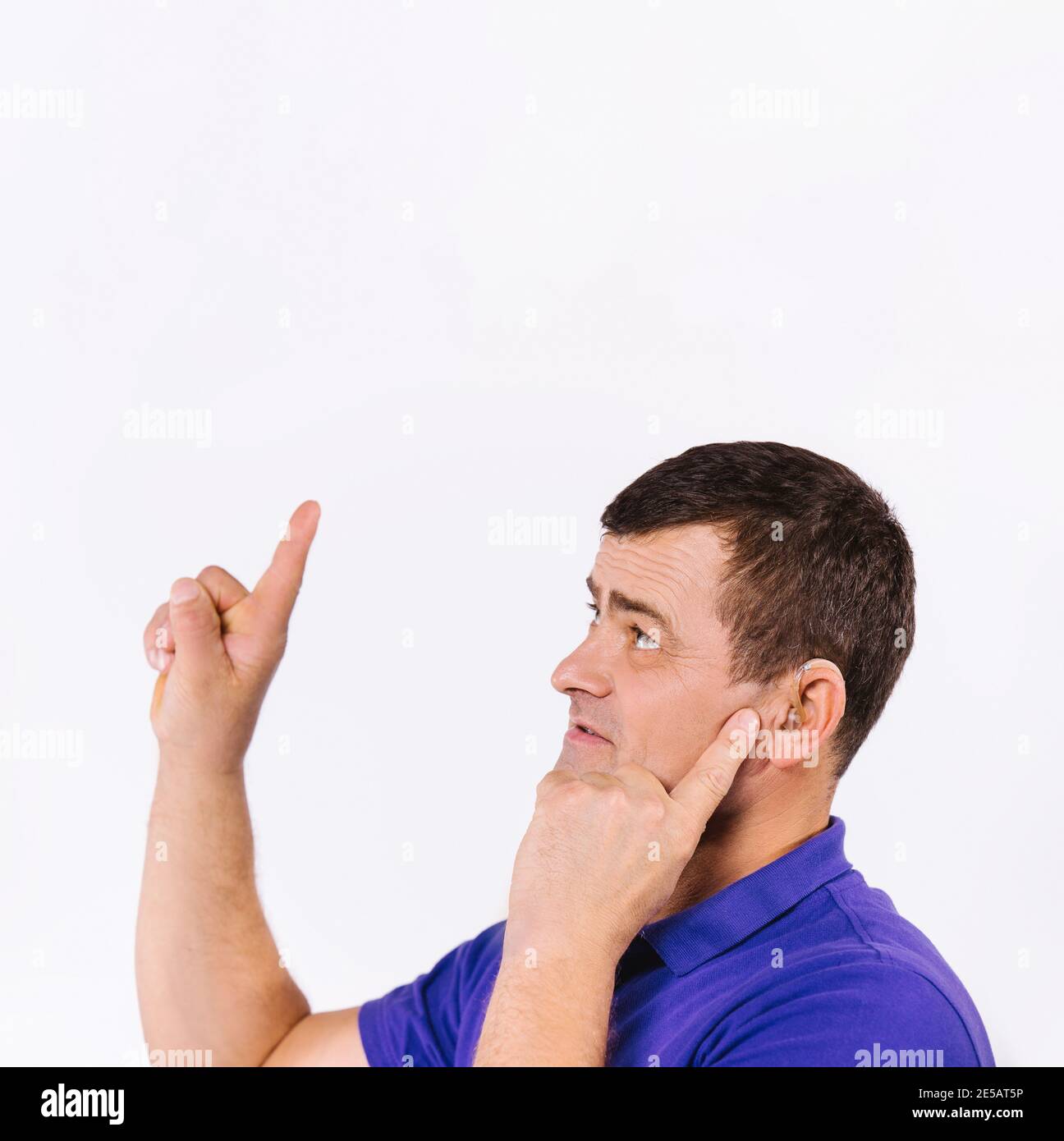 Cropped photo. A caucasian man speaking in sign language points up with ...