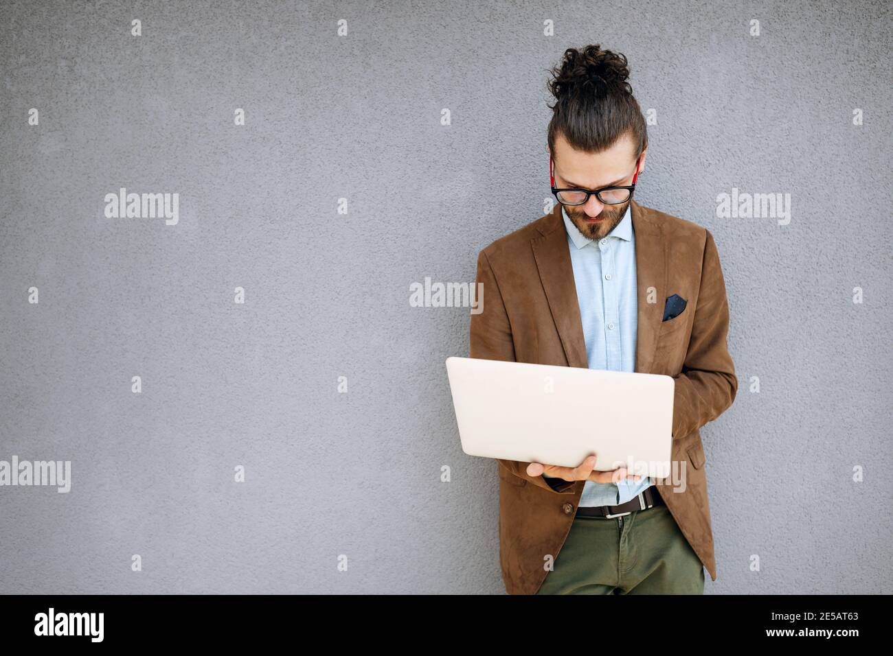 Portrait of young man using a laptop outdoor urban Stock Photo - Alamy