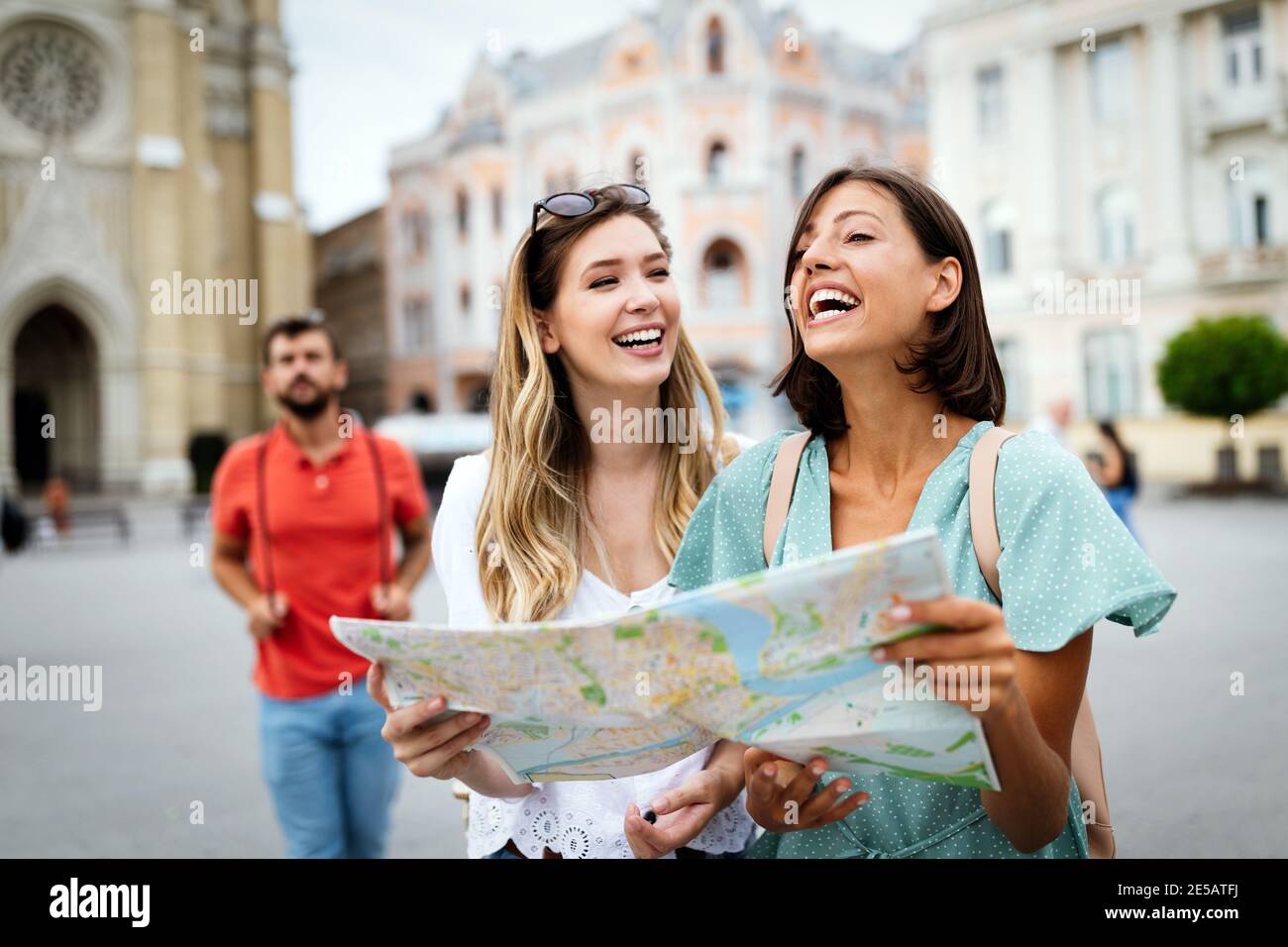 Happy traveling tourists sightseeing with map and having fun Stock ...