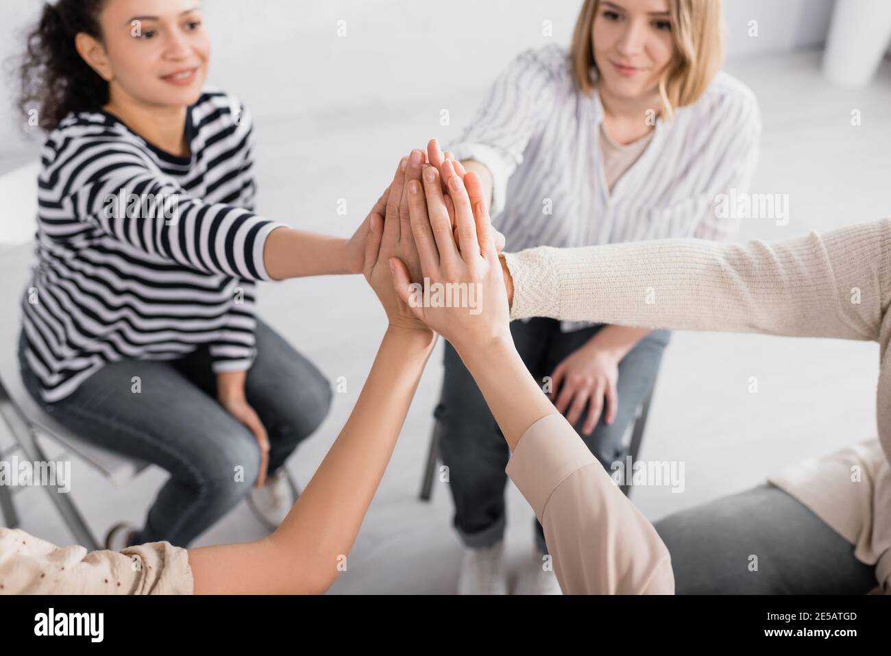 group of multicultural women holding hands together during seminar ...