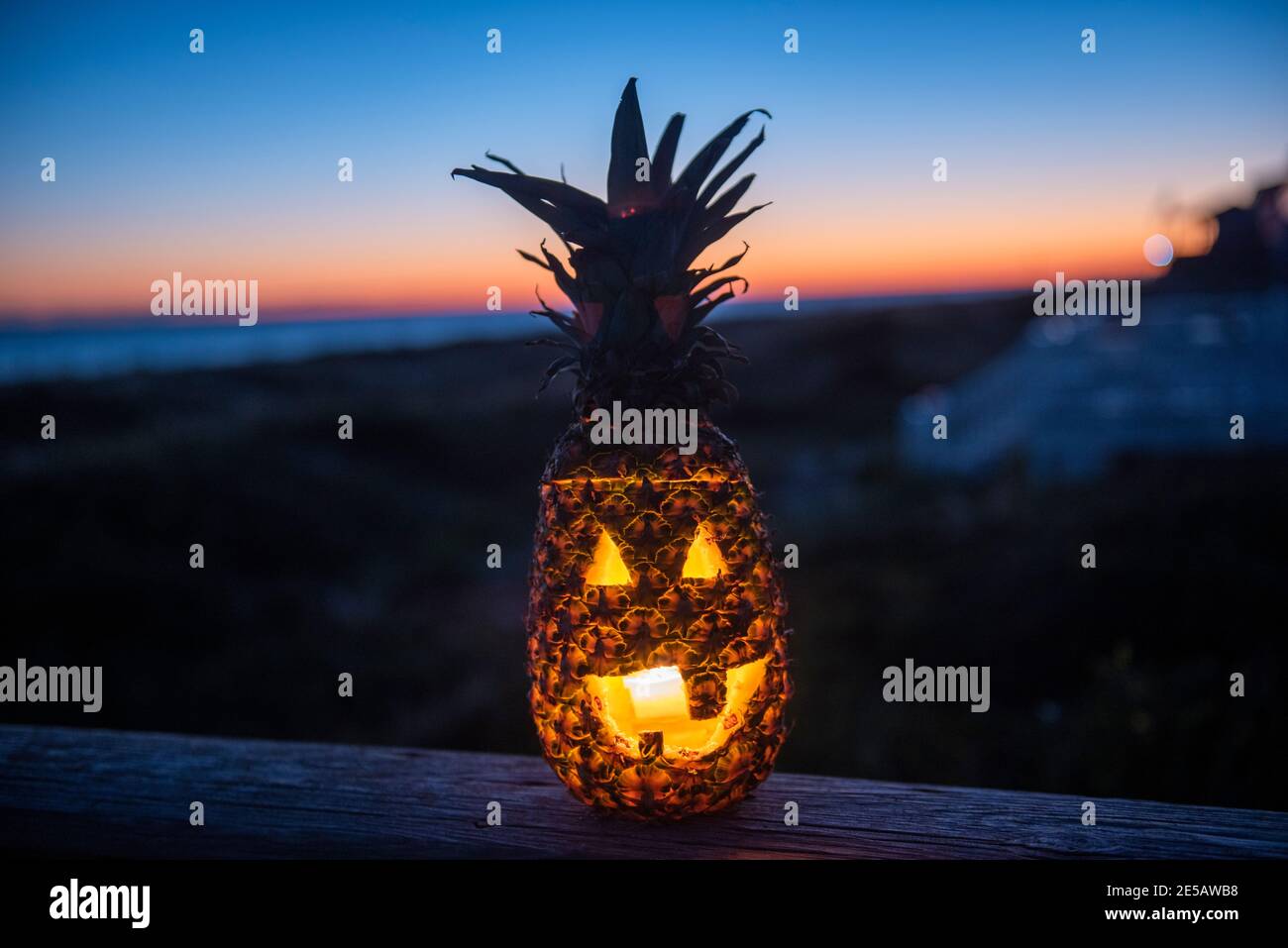 A pineapple carved out like a jack-o-lantern smiles a goofy grin for ...
