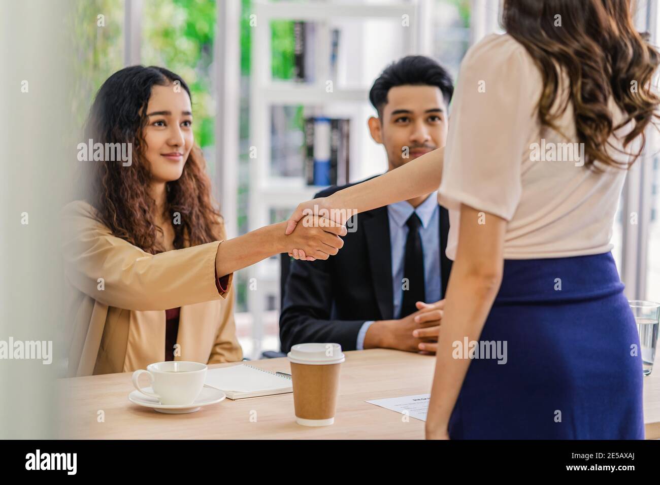 Closeup handshake after interview agreement between Young Asian woman ...