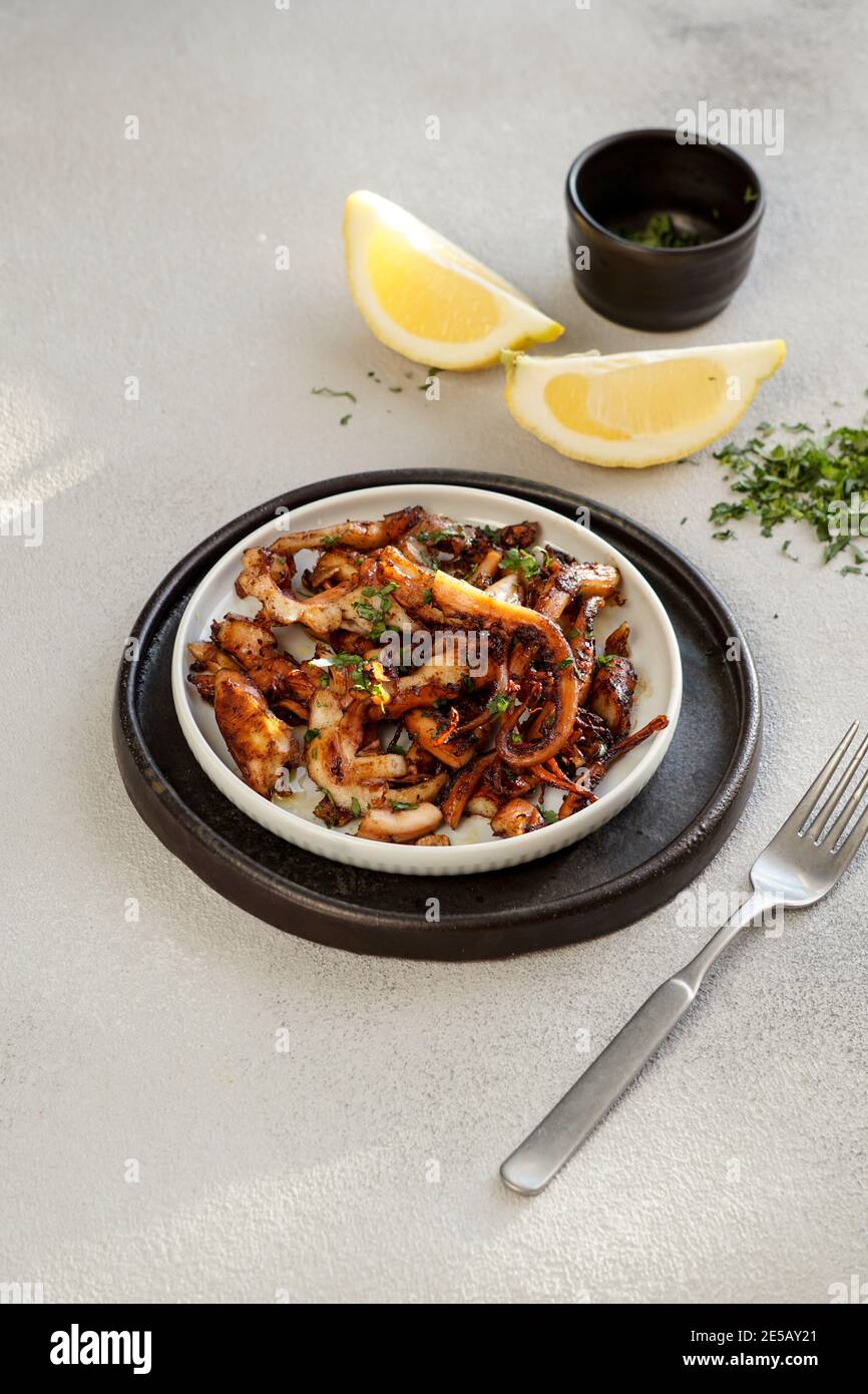 fried octopus pieces with lemon, pulpo frito, harsh direct sun light ...