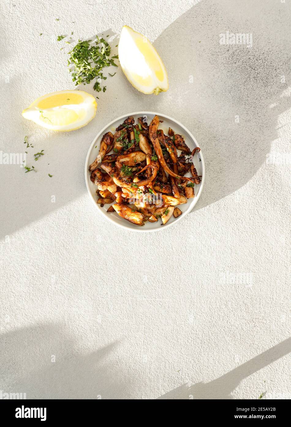 fried octopus pieces with lemon, pulpo frito, harsh direct sun light ...