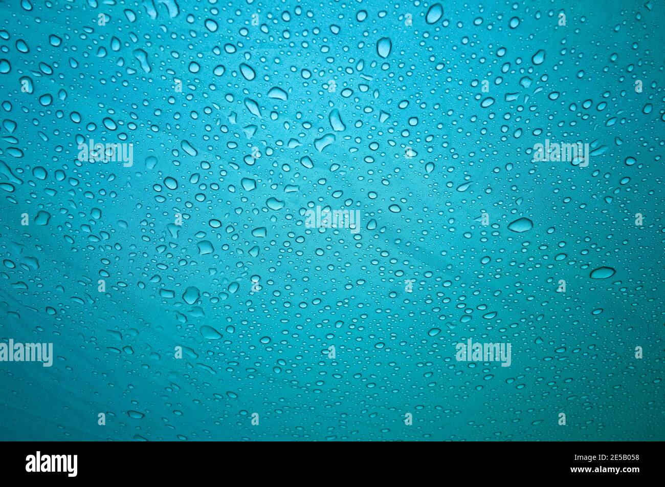 Rain drops on the solid abstract blue background. Bright shiny pattern ...