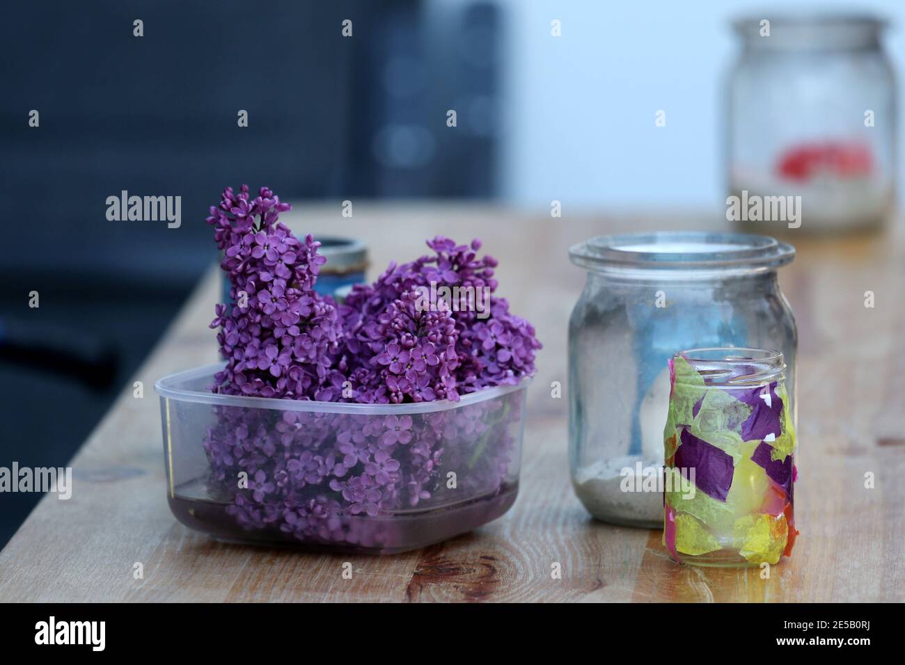 Selective focus shot of lilac flowers and glass jars on the table Stock ...