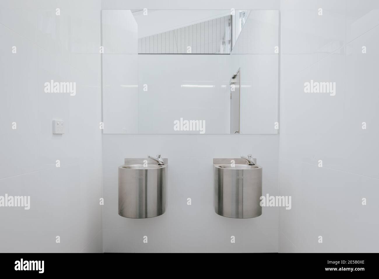 Stainless lavatory with a mirror inside a restroom Stock Photo - Alamy