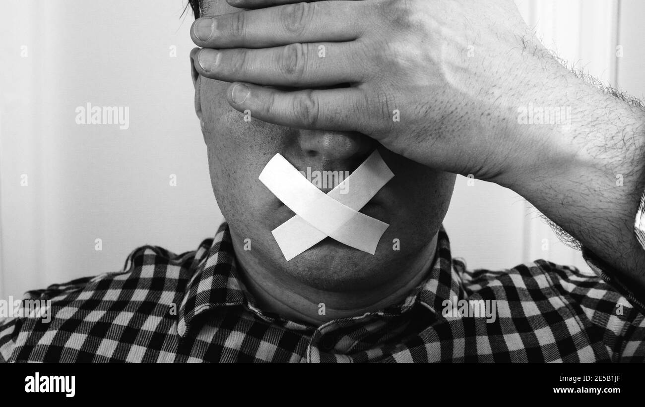 A man covers his eyes with his hand and mouth, a man with a closed face ...