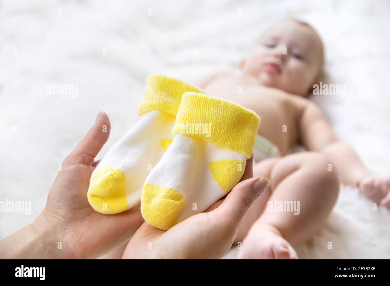 Mother puts socks on the little baby. Selective focus. People Stock ...