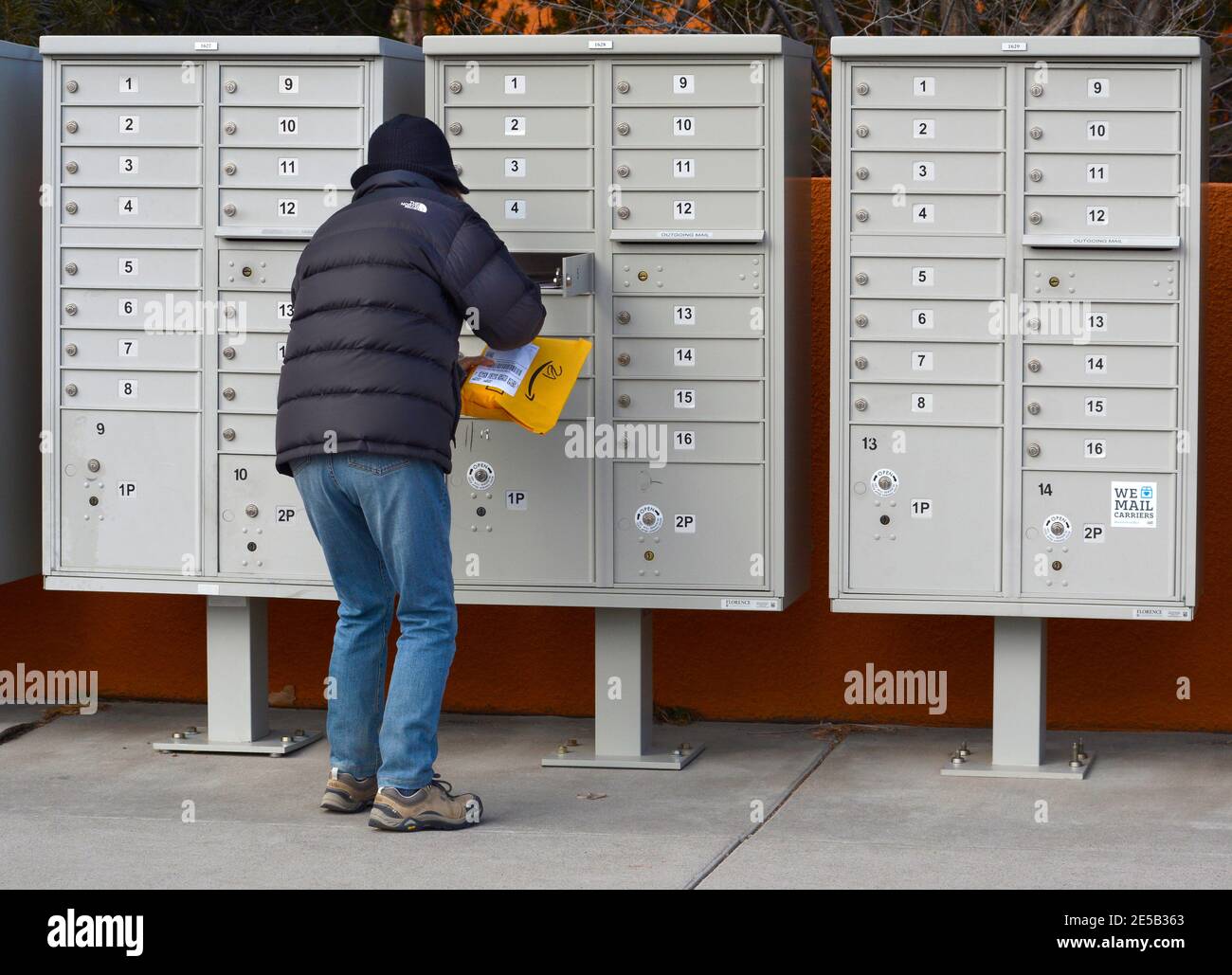A woman picks up her mail at a condominium cluster mailbox in Santa Fe ...